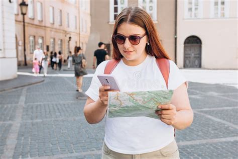 Attractive Young Female Tourist Is Exploring New City Redhead Girl Holding A Paper Map And