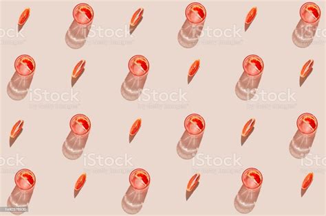 신선한 레모네이드 물 또는 칵테일 한 잔과 파스텔 베이지색 배경에 레드 블러드 오렌지 조각으로 만든 창의적인 패턴 여름 다과
