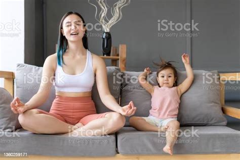 어린 엄마는 어린 딸과 함께 소파에서 요가를 연습합니다 연꽃 위치 2 3 살에 대한 스톡 사진 및 기타 이미지 2 3 살