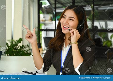 Friendly Asian Female Call Center Agent Wearing Headset Operating