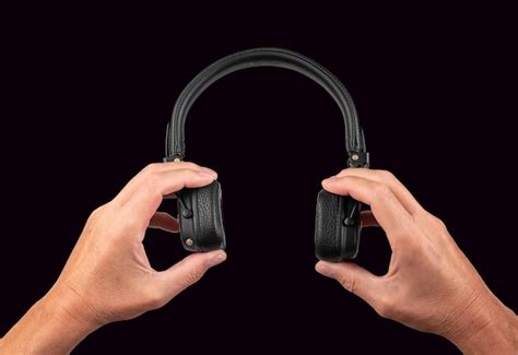 Premium Photo Hands Holding Headphones On Black Background Electronic