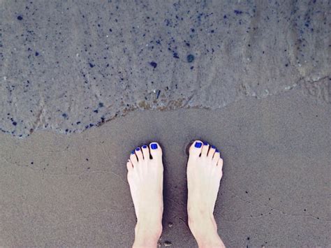 Premium Photo Low Section Of Woman Standing On Shore At Beach