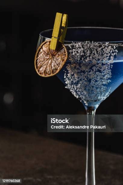 칵테일 항공 진 레몬 주스 마라스키노 비올레트 리큐어와 함께 마십니다 라임 칩과 코코넛 부스러기로 장식합니다 닫아 어두운 배경에 칵테일 과일에 대한 스톡 사진 및 기타