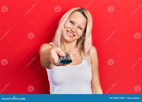 Beautiful Caucasian Blonde Woman Holding Television Remote Control