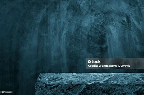 제품 몽타주 전시를 위한 빈 공간을 가진 파란 대리석 돌 카운터의 가장자리 진한 파란색 치장 벽토가 배경에 금이 간 콘크리트 벽과 함께 정면에서 대리석 돌 테이블의 테두리