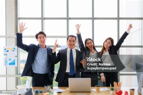 4명의 전문가로 구성된 행복한 비즈니스 팀이 현대적인 사무실 환경에서 성공을 축하하고 단합과 생산성을 촉진합니다 25 29세에