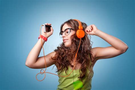 Красивая девушка в наушниках слушая к музыке и танцевать Стоковое Изображение изображение