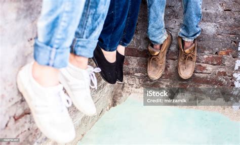 벽에 앉아서 친구 들과 시간을 보내는 스마트 폰을 사용 하 여 여러 민족 청소년의 다리를 닫습니다 가죽에 대한 스톡 사진 및 기타 이미지 Istock