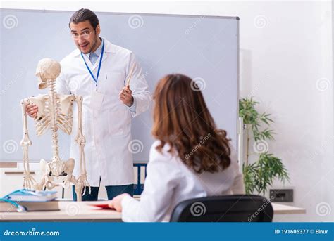 Joven Profesor De Medicina Esqueleto Y Estudiante De Sexo Femenino En El Cl Imagen De Archivo