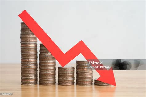 동전 쌓기 막대 차트와 빨간색 그래프가 나무 테이블에 흰 벽 배경으로 아래쪽으로 향하고 있다 손실에 대한 스톡 사진 및 기타 이미지 Istock