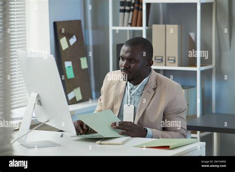 Portrait Of Black Businessman Using Desktop Computer In Office And