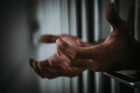 철 감옥 수감자 개념을 잡기 위해 필사적 인 남자의 손태국 사람들이 해방되기를 바랍니다 프리미엄 사진