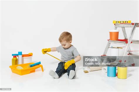 재건축 아파트 룸 흰색 배경에 고립에 대 한 장비와 노란색 장갑에 작은 귀여운 소년 벽지 액세서리를 붙이기 그림 도구 집 수리 부모 어린 시절 개념 개선에 대한 스톡 사진