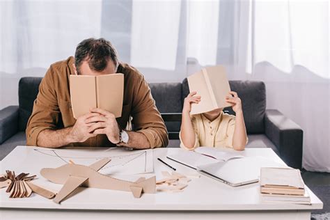 아버지와 함께 집에서 모델링 하는 동안 책 뒤에 얼굴을 숨기고 아들 Diy에 대한 스톡 사진 및 기타 이미지 Diy 가정