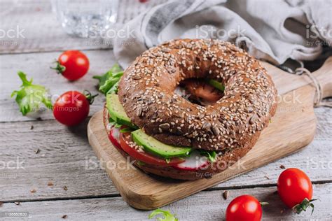 나무 보드와 테이블 배경에 크림 아보카도 토마토 무와 녹색 잎 베이글 건강 한 아침 식사 음식 맛 있는 균형 잡힌 음식