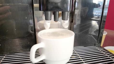 Process Of Espresso Machine Pouring Milk And Coffee Into White Cup