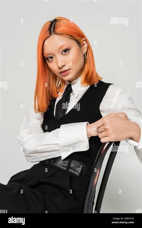 Appealing And Young Asian Woman With Dyed Red Hair Wearing White Shirt