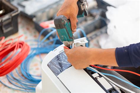 클라이언트 하우스에 에어컨을 설치하는 기술자 에어컨 장치에 전선을 장착하는 전기 기사 에어컨 장치를 고정하는 수리공 유지 보수 및 수리 개념 25 29세에 대한 스톡 사진