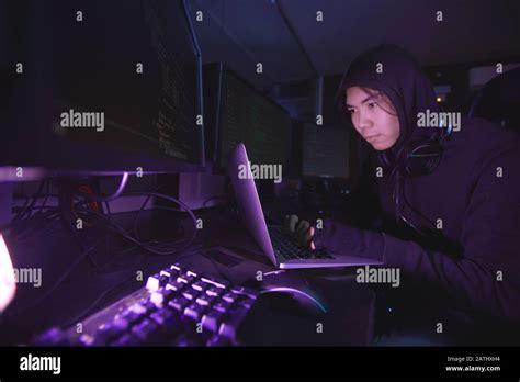 Asian Cyber Security Hacker Wearing Hood While Working On Programming