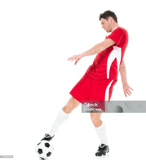 축구 유니폼을 입고 축구공 스포츠를 들고 흰색 배경 앞에서 발로 차는 전체 길이 1인 1인 사이드 뷰 프로필 보기 3039세 잘생긴 남성 중성인 남성 중견 축구 선수 30