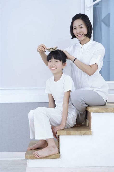 东方人儿童中年人两个人家庭母亲女儿坐笑微笑露齿笑竖图室内白天正面纯洁楼梯亚洲一把撑握阴影服装反射