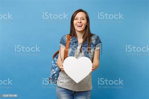 배낭 복사 공간 파란색 배경에 고립 된 하얀 마음을 들고와 데님 옷에서 젊은 즐거운 아름 다운 여자 학생의 초상화 고등학교에서