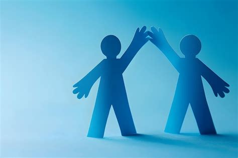 Blue Paper Cutout Figures Celebrating On Light Blue Background Teamwork Togetherness Unity