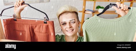 Pleased Young Woman With Radiant Smile And Trendy Hairstyle Holding