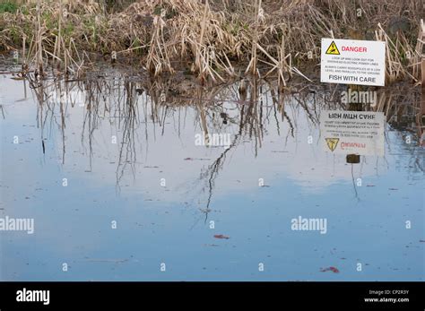 Canal Surface With Sign Warning Of Submerged Electrical Cabling Stock