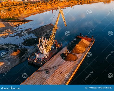 Crane Is Loading Sand And Gravel Onto Barge Ship For River Transport
