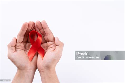 인식을 돕고 흰색 배경에 빨간색 리본을 들고 있는 사람의 손과 텍스트 복사 공간이 있습니다 세계 에이즈의 날 의료 및 의료 개념
