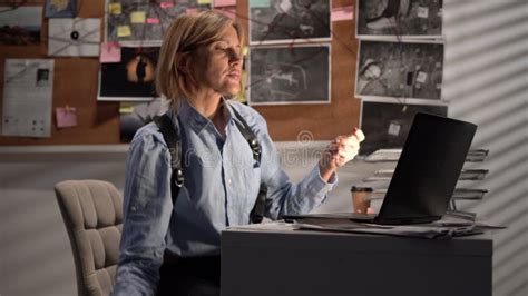 Detective Working At Desk In Her Office Using Laptop Computer