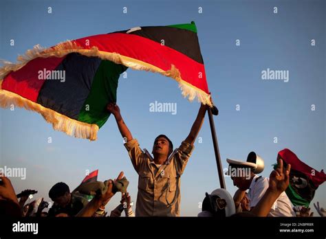 A New Cadet For The Libyan Rebel Army Holds A Pre Moammar Gadhafi Flag