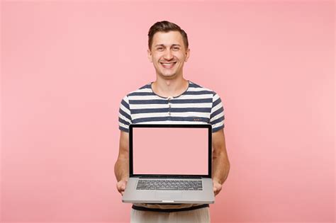 빈 블랙 빈 화면 디스플레이 복사 공간 파스텔 핑크 배경에 고립 된 노트북 컴퓨터를 손에 들고 젊은 남자의 초상화 사람들이
