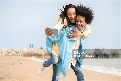 행복한 아프리카 계 미국인 커플이 함께 해변에서 즐거운 시간을 보내십시오 25 29세에 대한 스톡 사진 및 기타 이미지 25