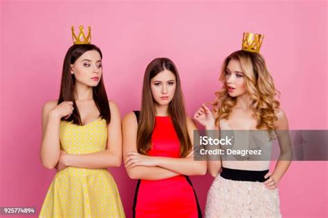 골드 크라운 머리 보고 오만 Diadem 없이 그들의 불행 한 실망된 하는 친구에 게 핑크 배경 위에 서 교차 손으로 두 자랑 여자 속물에 대한 스톡 사진 및 기타 이미지