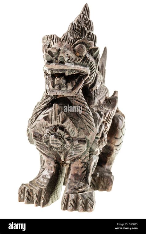 A Wooden Indonesian Dragon Statuette Isolated Over A White Background
