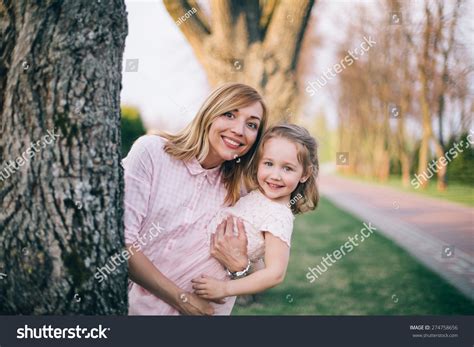 Hide And Seek Young Mother And Her Cute Daughter Hiding Behind The
