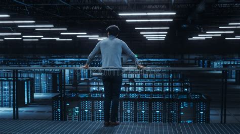 Data Center Engineer Looking Down From A Balcony On Server Farm Cloud Computing Specialist