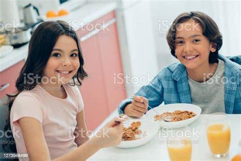 아침 식사를 위해 맛있는 콘플레이크를 선호하는 미풀한 아이들 2명에 대한 스톡 사진 및 기타 이미지 2명 가정 생활 가정