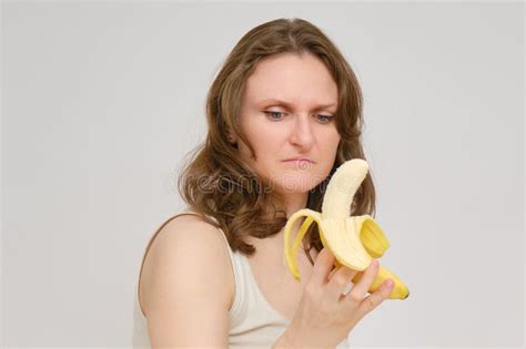 A Woman With Doubt And Contempt Looks At A Banana A Studio White B Stock Image Image Of