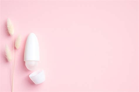 분홍색 배경에 마른 꽃이있는 빈 롤 온 데오도란트 병 천연 유기농 발한 억제제 땀 방지 컨셉 플랫 레이 상단 보기 0명에 대한