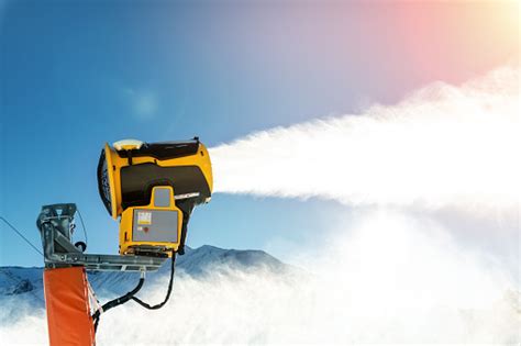 눈가루를 만드는 피스트 근처에서 인공 눈 대포를 작동합니다 화창한 날에 힐랜드 알프스 산 겨울 리조트의 스키 리프트 로프웨이 사람들이 즐길 수있는 내리막 슬로프 0명에 대한