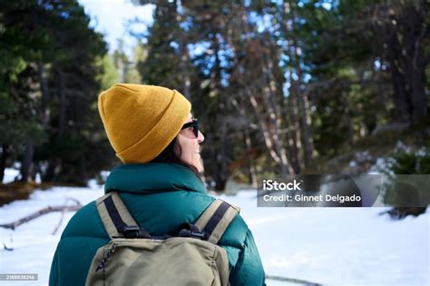 눈 덮인 숲 속을 하이킹하는 알아볼 수 없는 여성이 쾌활하게 바라보는 뒷모습 걷기에 대한 스톡 사진 및 기타 이미지 걷기 겨울 겨울 코트 Istock