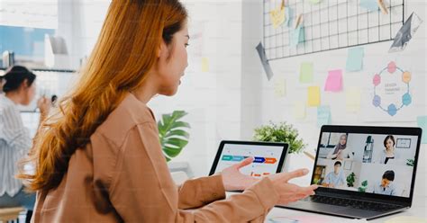 노트북을 사용하는 아시아 사업가들은 뉴 노멀 사무실에서 화상 통화 회의에서 계획에 대해 비즈니스 브레인스토밍에 대해 논의하는 동료들과 이야기합니다 코로나 바이러스 이후