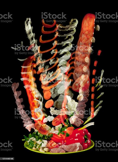검은 색 배경에 고립 된 야채 고기 토마토 양배추 마늘 당근 허브 조각이 접시에 들어갑니다 예술적 효과로 흐려집니다 모션 역학 및 비행의 개념 개념에 대한 스톡 사진 및