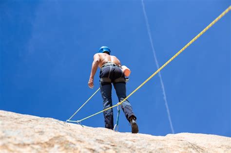 Premium Photo Rear View Of Shirtless Man Climbing Rock