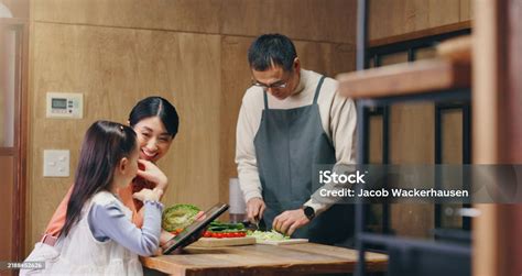 부모 소녀 및 가정에서 요리 학습 및 부엌에서 음식 튜토리얼 및 조리법에 만족합니다 사람들 엄마와 아빠 일본의 가정집에서 터치스크린과 식사 준비 3 명에 대한 스톡 사진 및