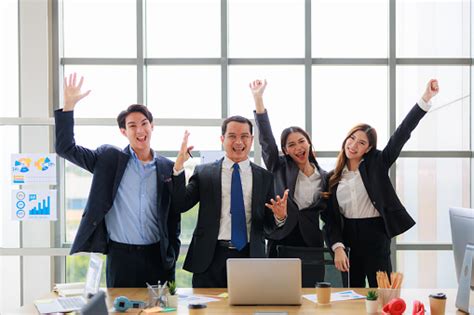 4명의 전문가로 구성된 행복한 비즈니스 팀이 현대적인 사무실 환경에서 성공을 축하하고 단합과 생산성을 촉진합니다 25 29세에 대한 스톡 사진 및 기타 이미지 Istock