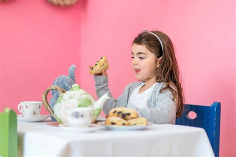 귀여운 소녀 먹는 A Scone 에 그녀의 차 파티 테이블 귀여운에 대한 스톡 사진 및 기타 이미지 귀여운 남녀관계 문제